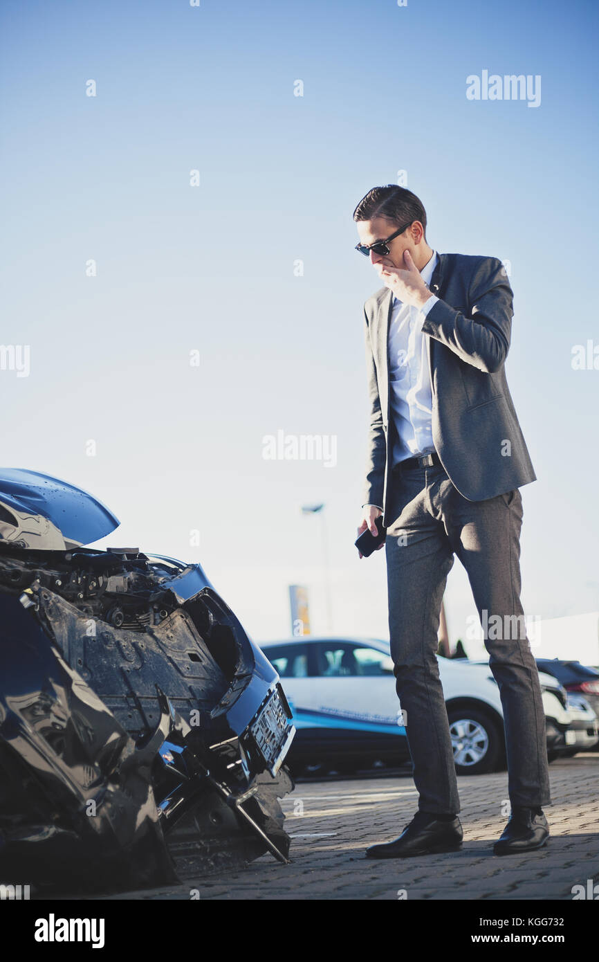 Male adult man in a black winter coat and sunglasses checking damaged ...