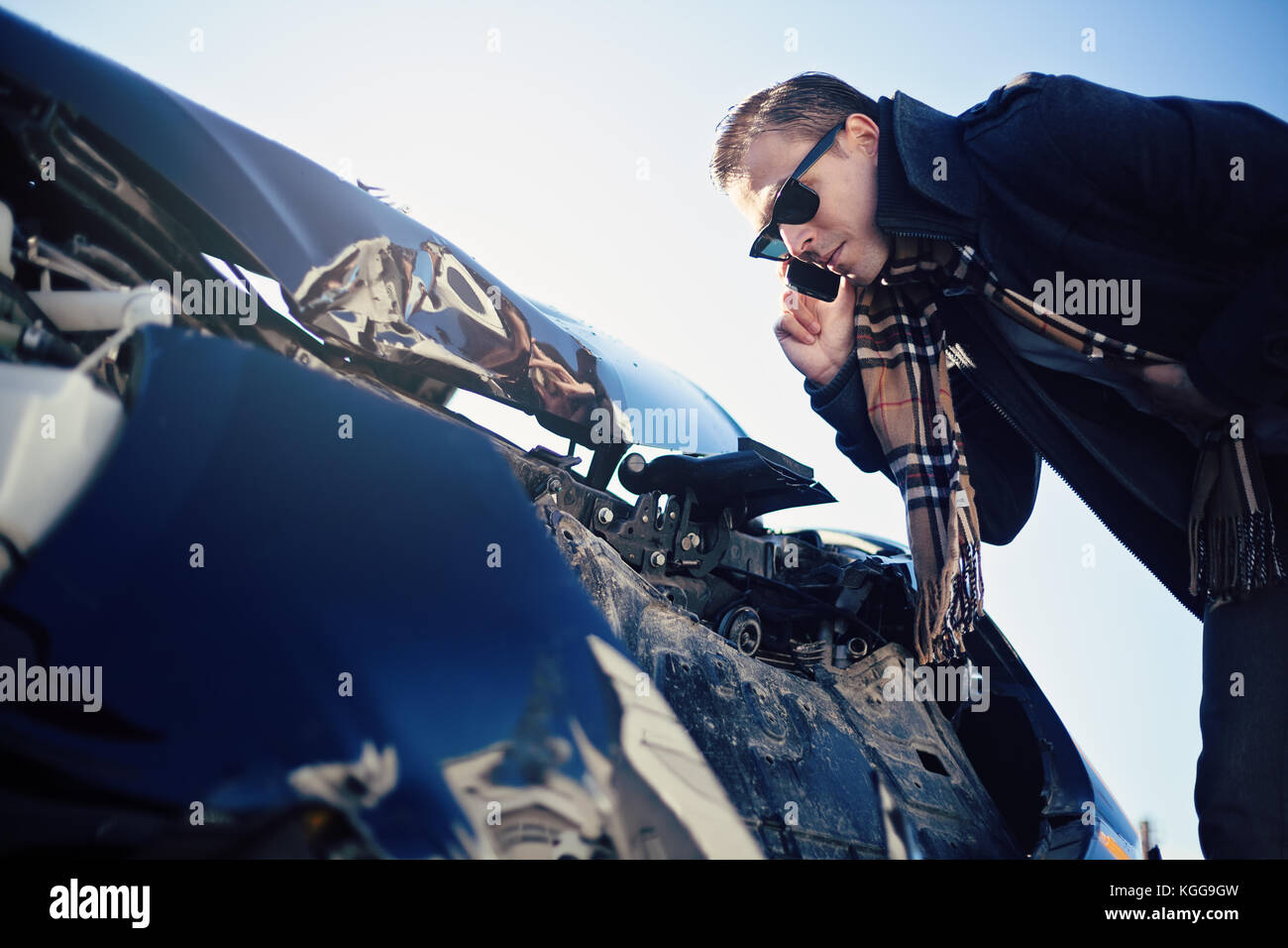 Male adult man in a black winter coat and sunglasses checking damaged ...