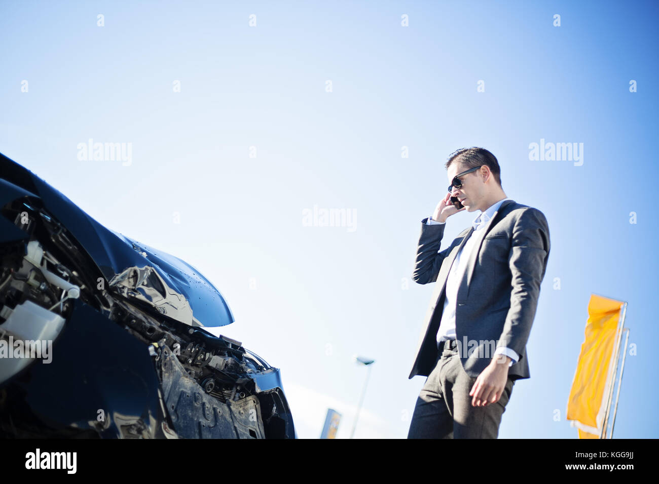 Male adult man in a black winter coat and sunglasses checking damaged ...