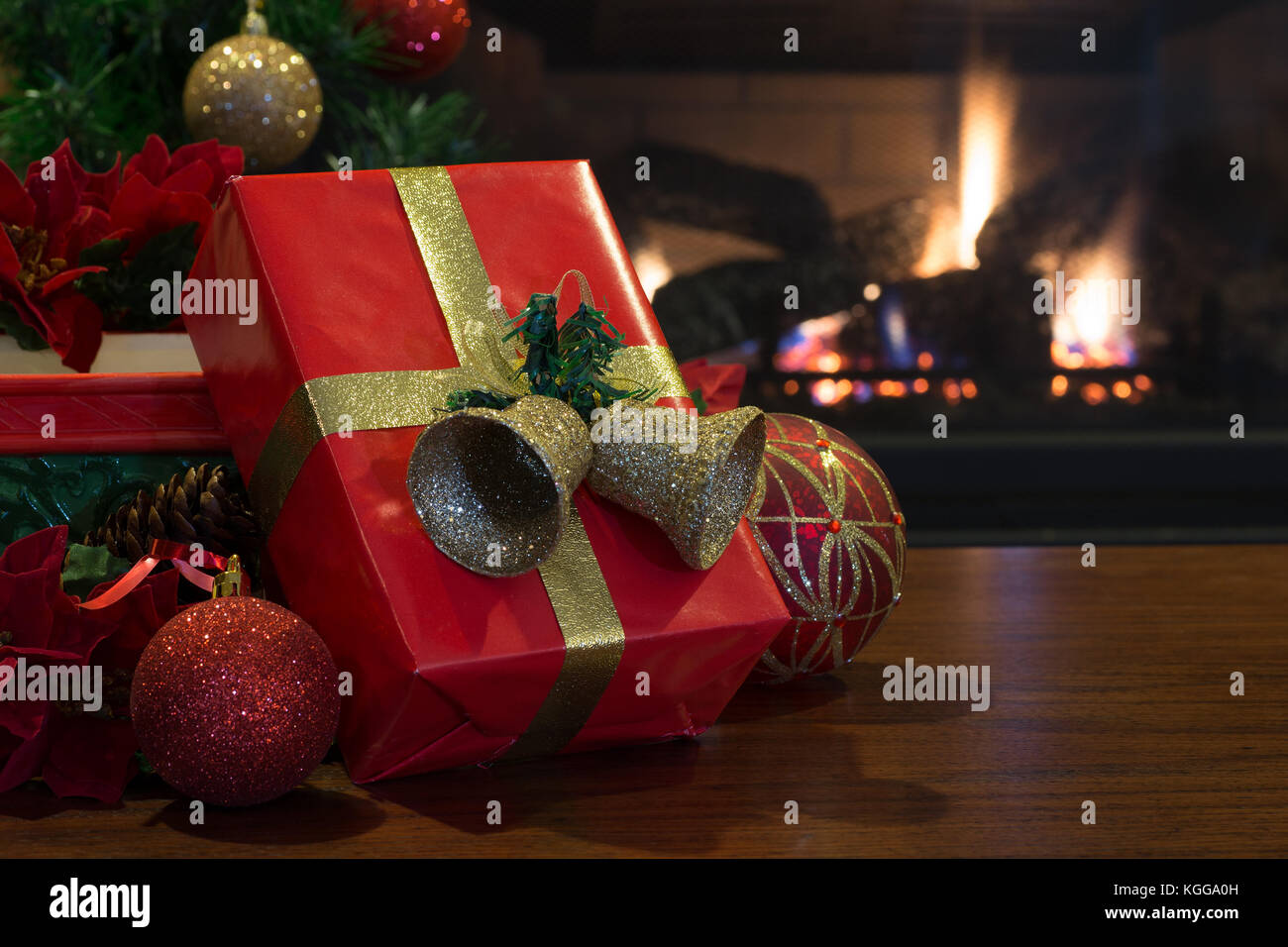 Red Christmas presents with decorations and fireplace in background ...