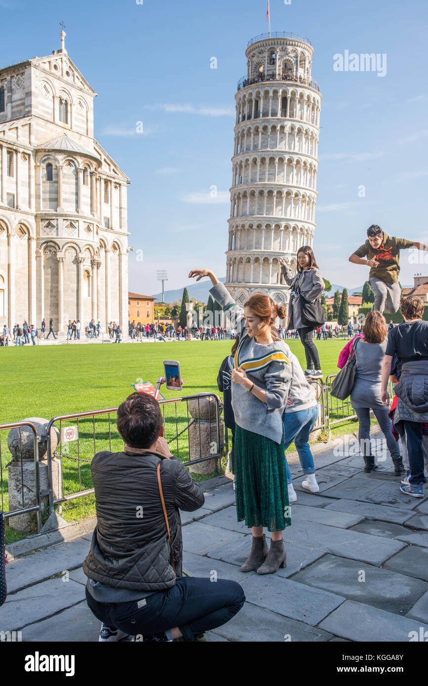Pisa, Italy - Oct 28th, 2017: Tourists emulating the famous holding or ...