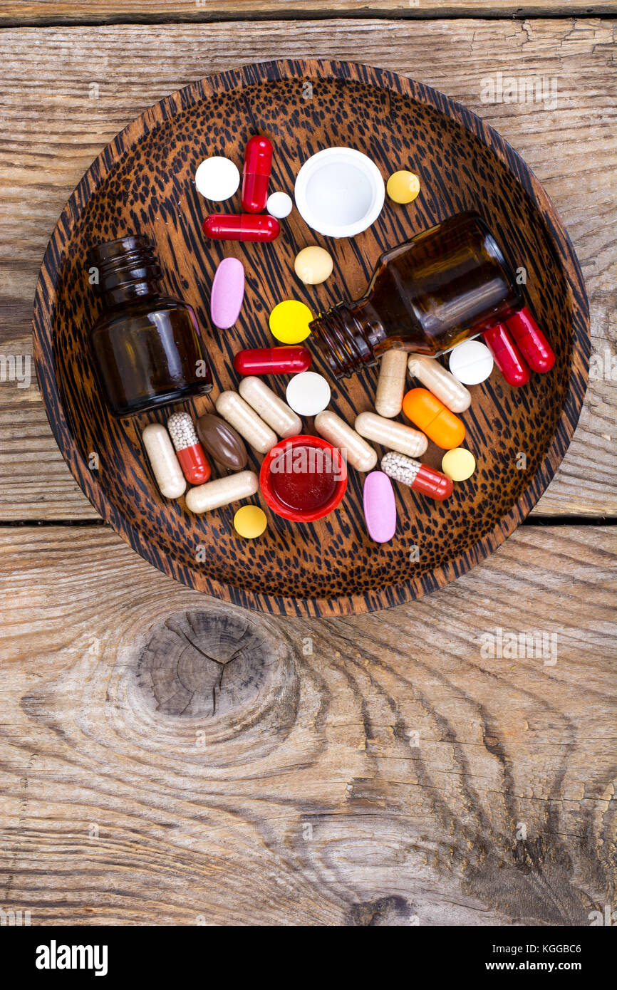 Different tablets, pills and capsules on wooden background. Studio ...