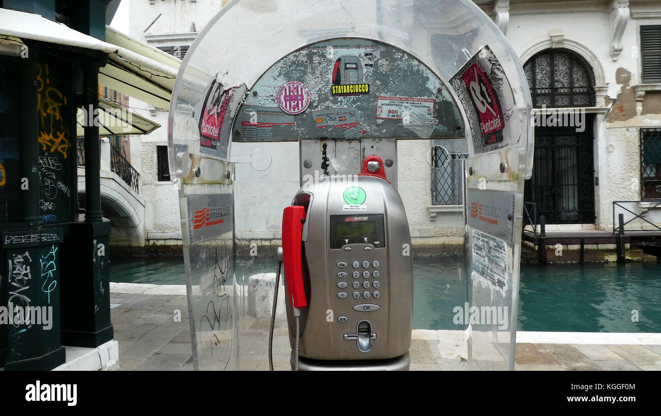 Old fashioned pay phone in sticker adorned perspex bubble canal side in ...