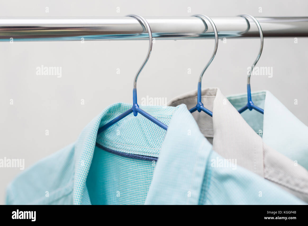 Blue shirts on hangers hanging on a pipe Stock Photo - Alamy