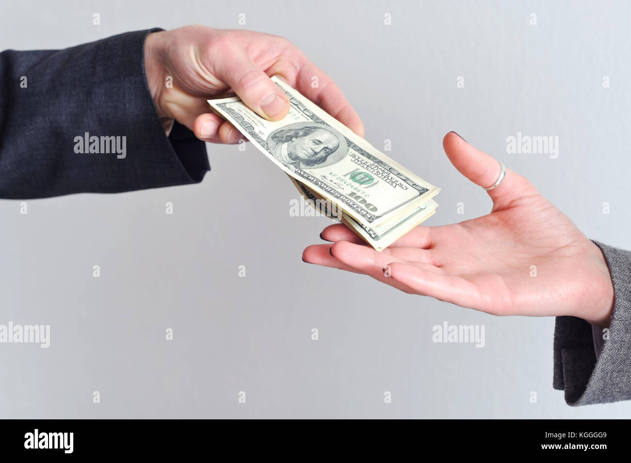 Man's hand giving money, a female hand takes them Stock Photo - Alamy