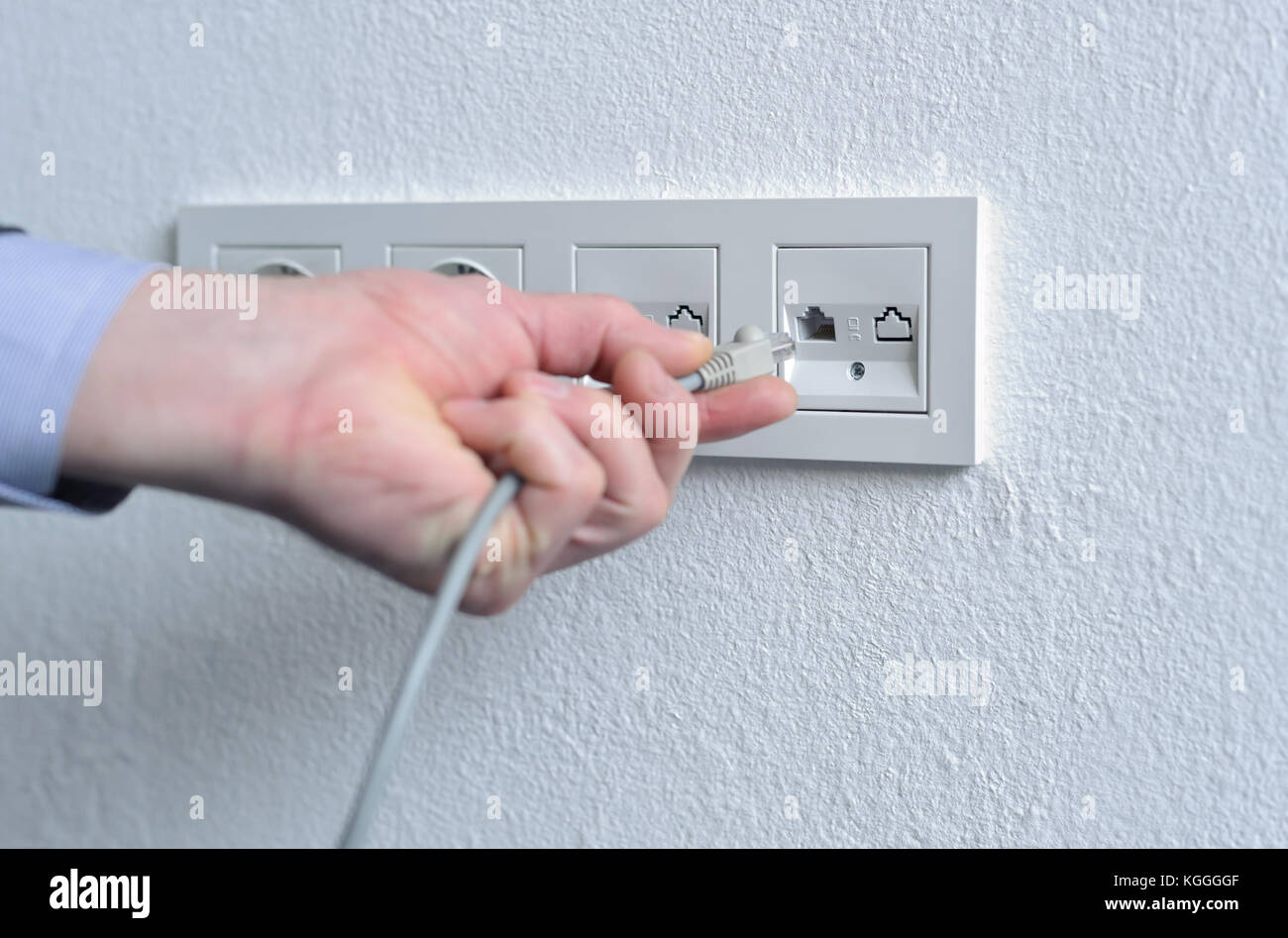 homans hand puts the network cable into the outlet Stock Photo - Alamy