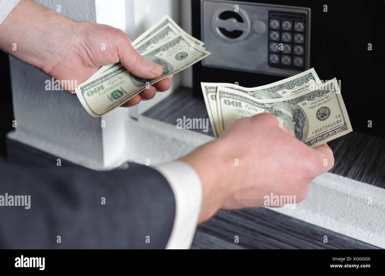 Human hands holding money against a background of safe Stock Photo - Alamy