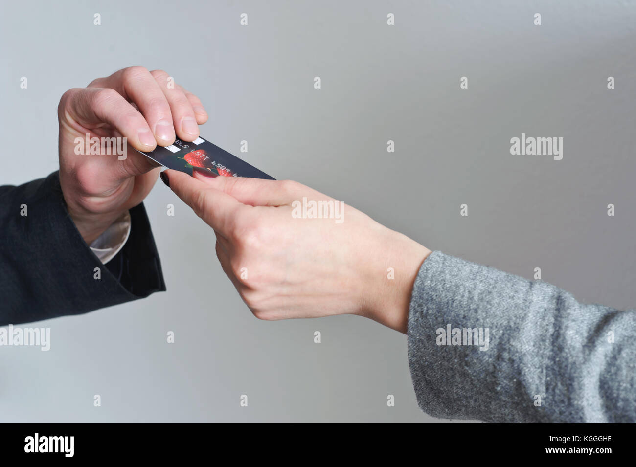 A woman's hand is giving a credit card and a man's hand is taking it ...