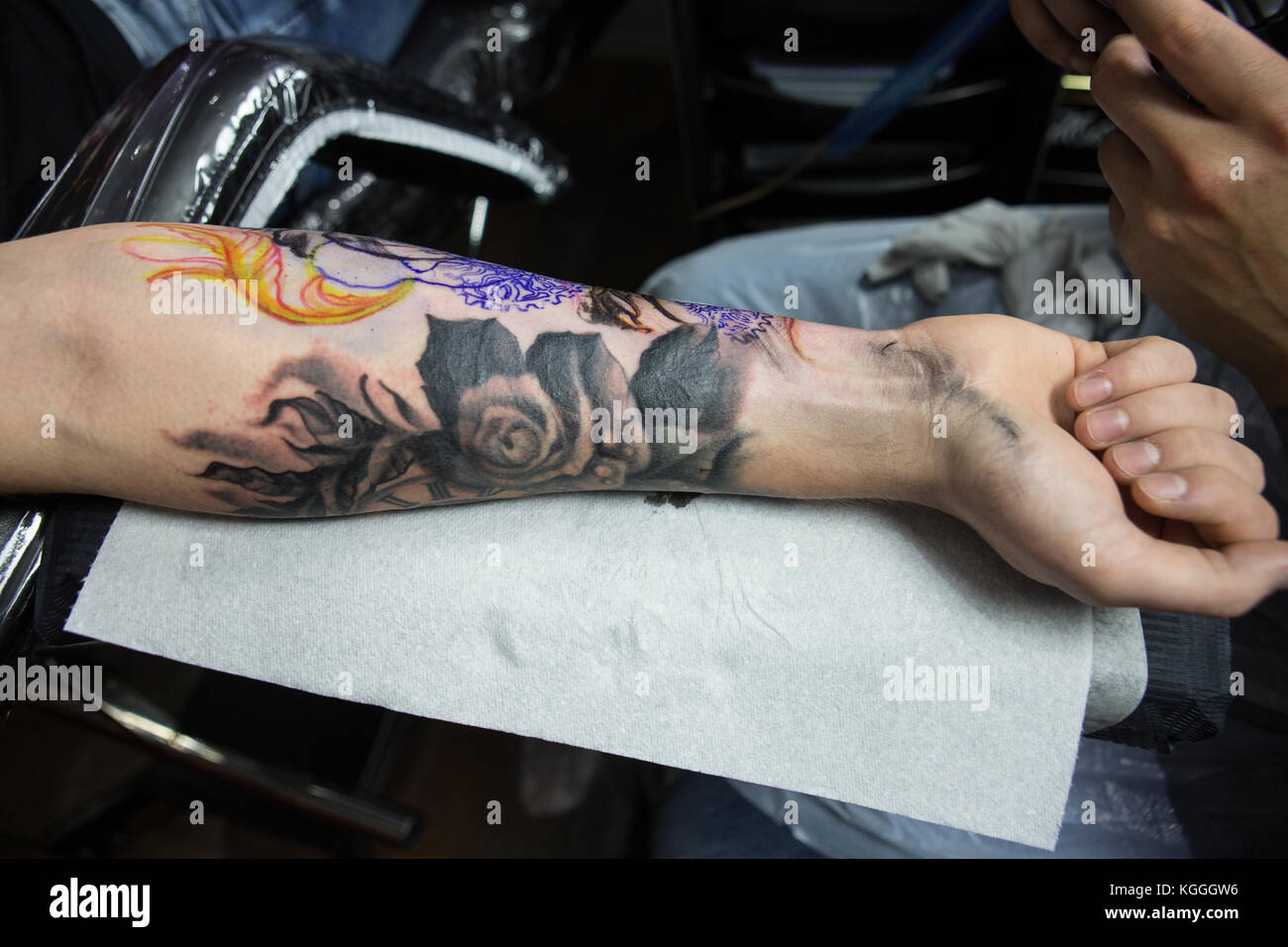 A Tattoo Artist at Work,A tattoo artist inks a designed onto the back ...