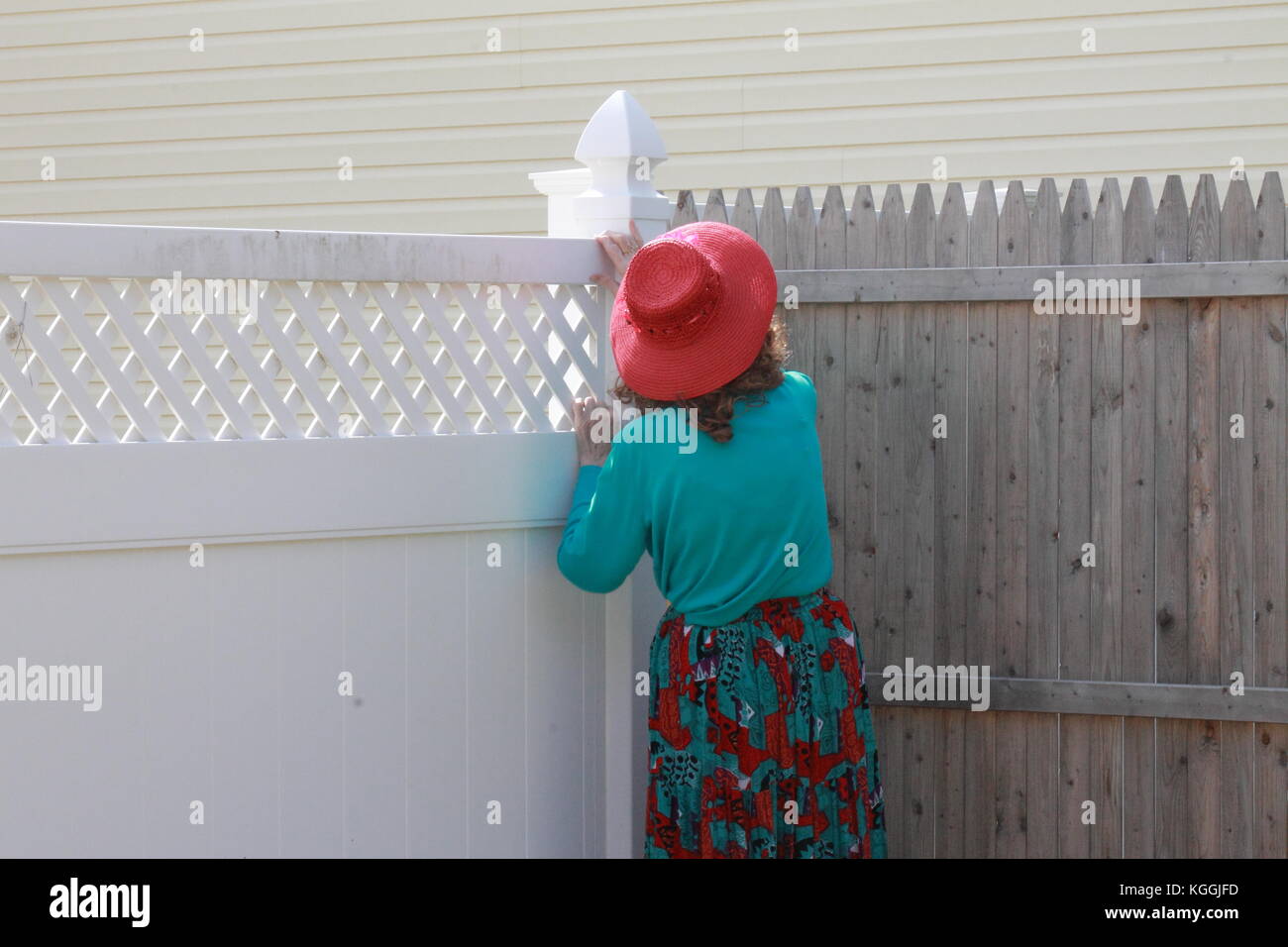 Woman looking over garden fence hi-res stock photography and images - Alamy