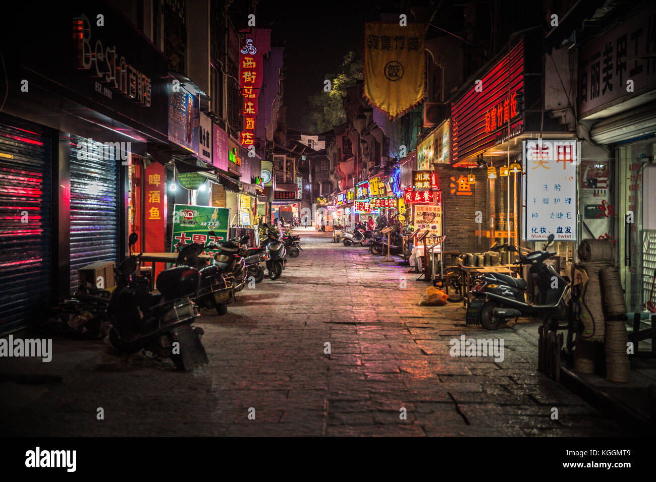 Bustling and full of neon lit signs and market stalls selling lots of ...