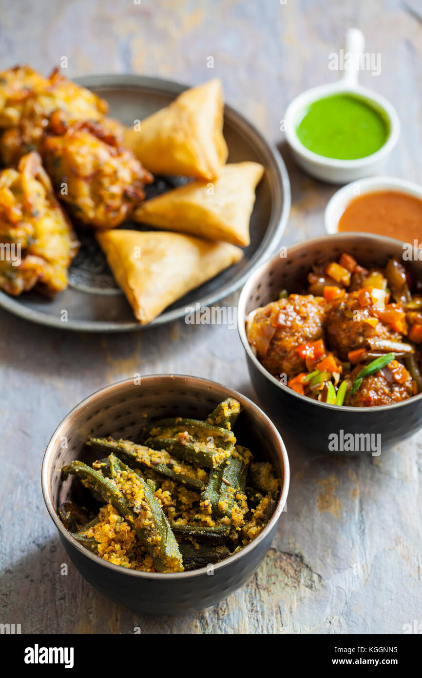Selection of Indian dishes: samosas, onion bhaji, manchurian balls and ...
