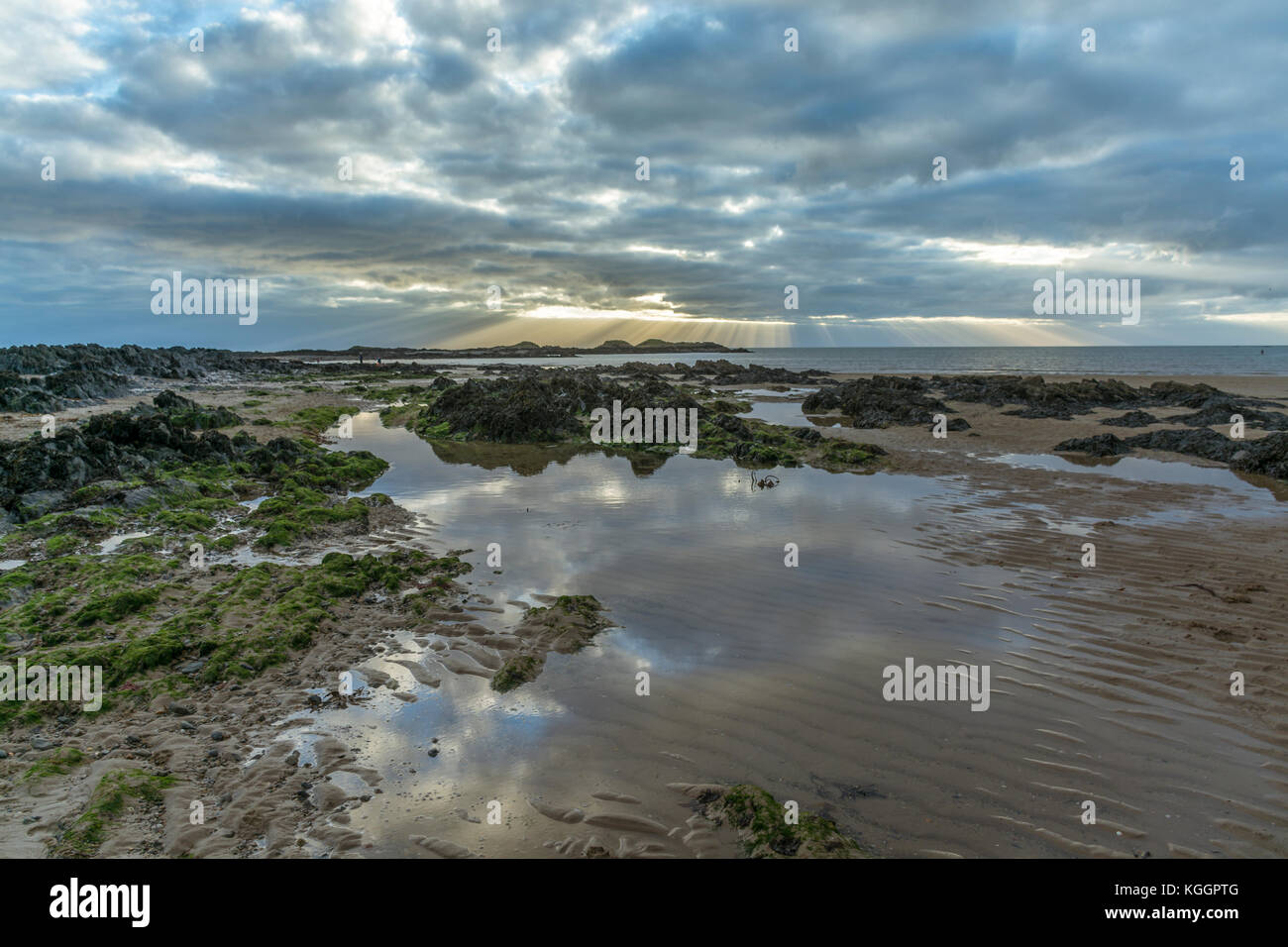 Sun beams on the horizon at the Town beach, Rhosneigr on Anglesey Stock ...