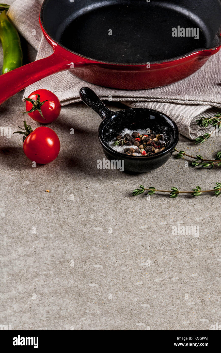 Grey stone culinary background with empty black pan and selection of ...