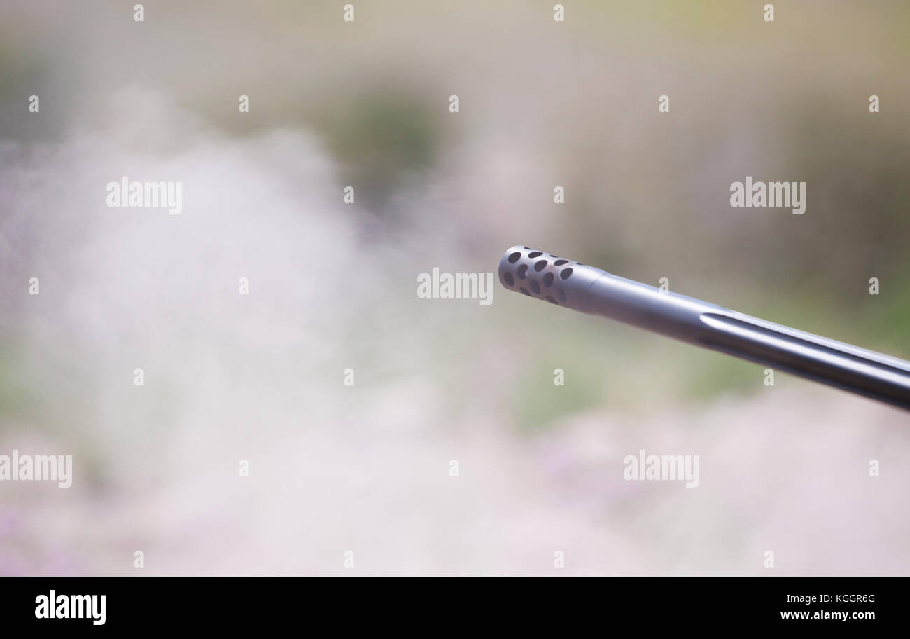 Dust flying up around a rifle muzzle after a shot Stock Photo - Alamy