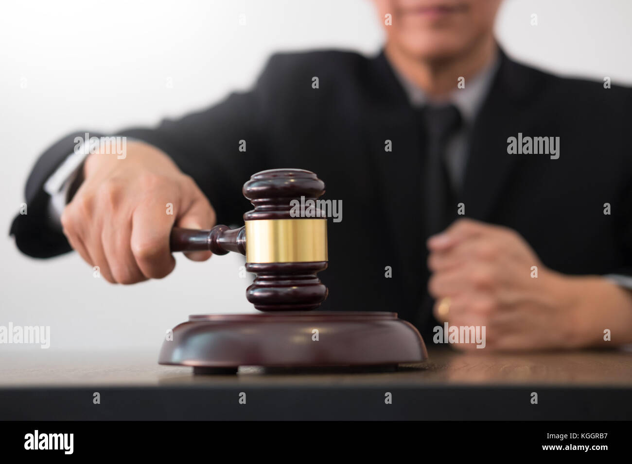 Male Judge lawyer In A Courtroom Striking The Gavel on sounding block ...