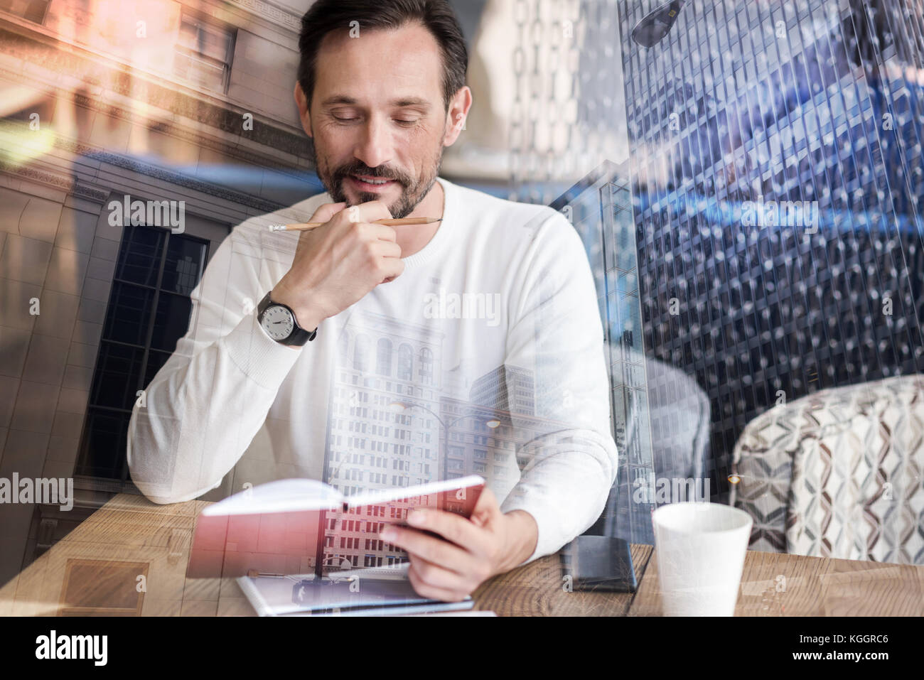 Young man revising his notes while sitting in cafe Stock Photo - Alamy