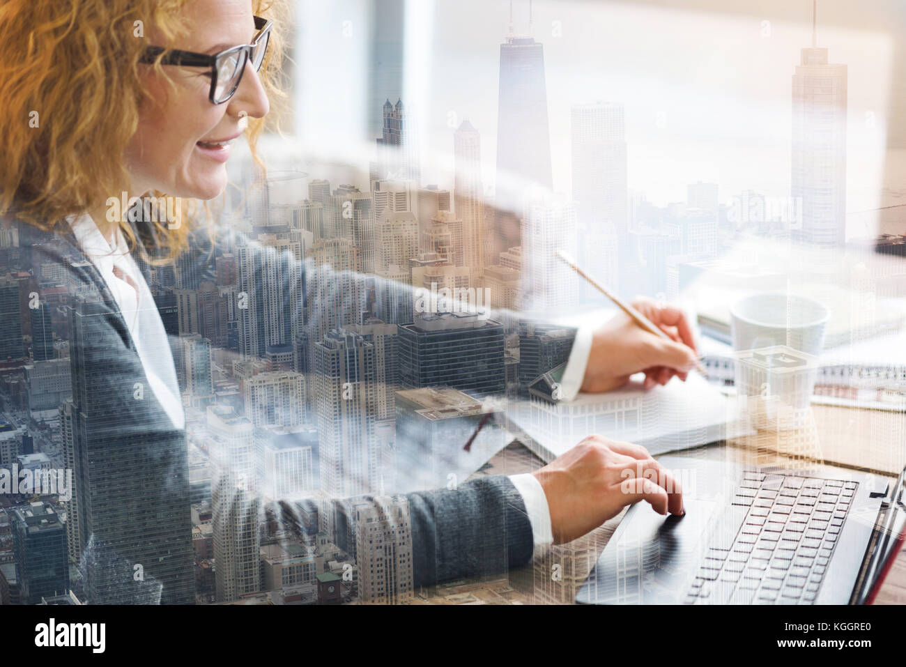 Cheerful woman smiling while reading something online Stock Photo - Alamy