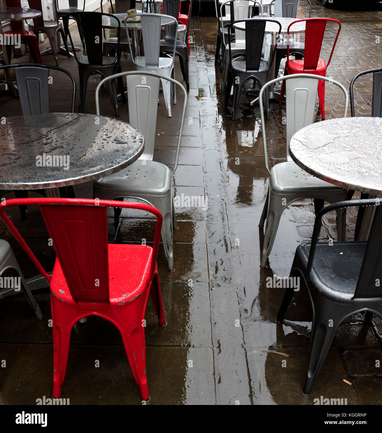 Wet Cafe Tables, Red Chair and cobbles, Winchester Stock Photo - Alamy