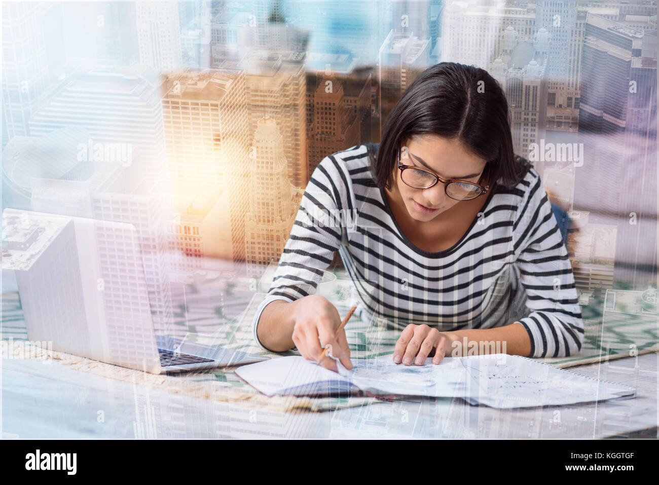 Thoughtful young designer drawing in her notebook Stock Photo - Alamy