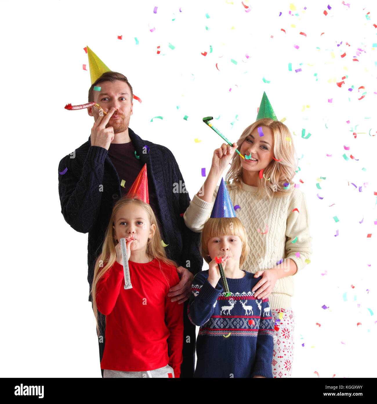 Family blowing party trumpets with confetti celebrating new year Stock ...