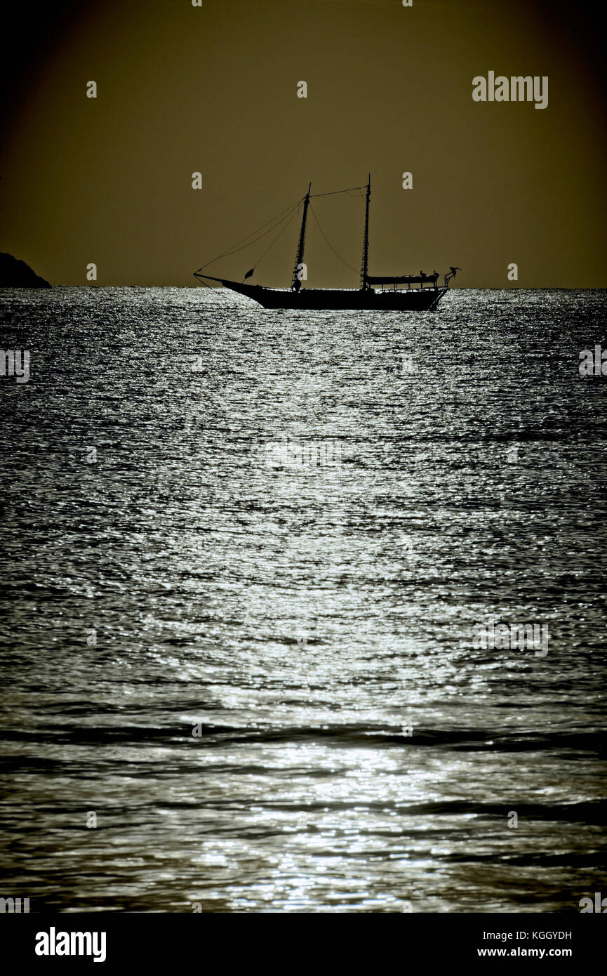 sailboat ancored in the bay with sails down Stock Photo - Alamy