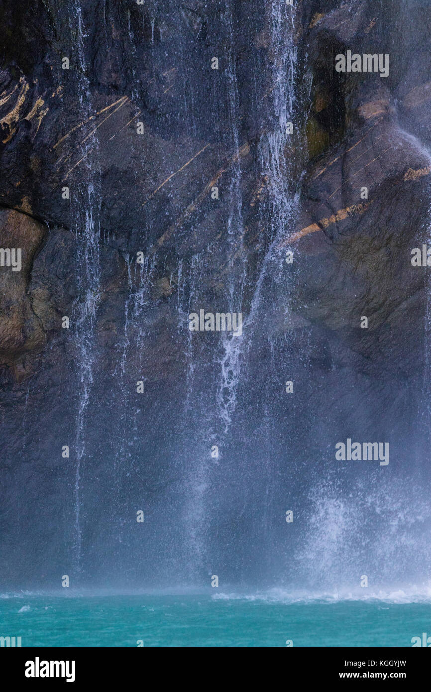 Waterfall flowing into colourful Knight Inlet, Great Bear Rainforest ...