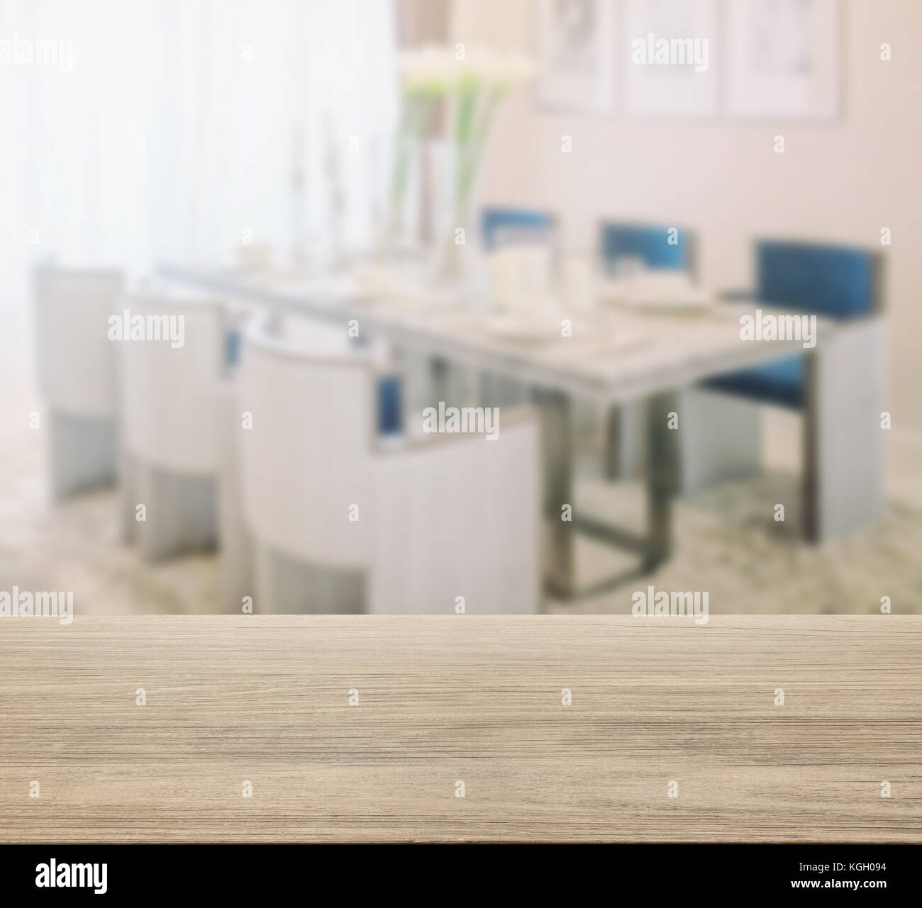 wooden table top with blur of dining table and comfortable chairs with ...