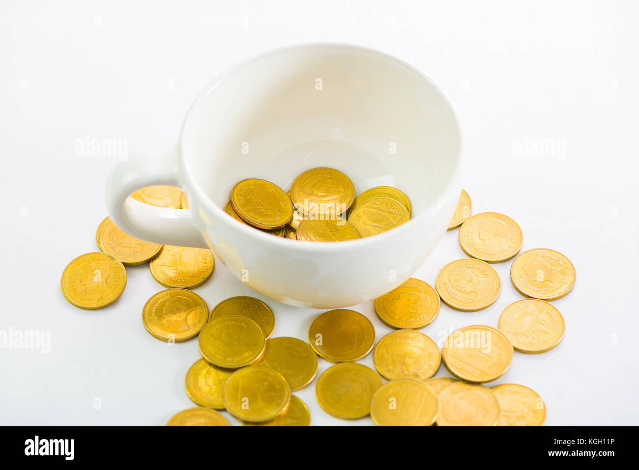 Golden coins in a white cup of coffee on the white background, saving ...