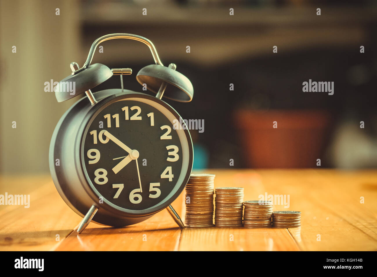 Alarm clock and step of coins stacks on working table, time for savings ...