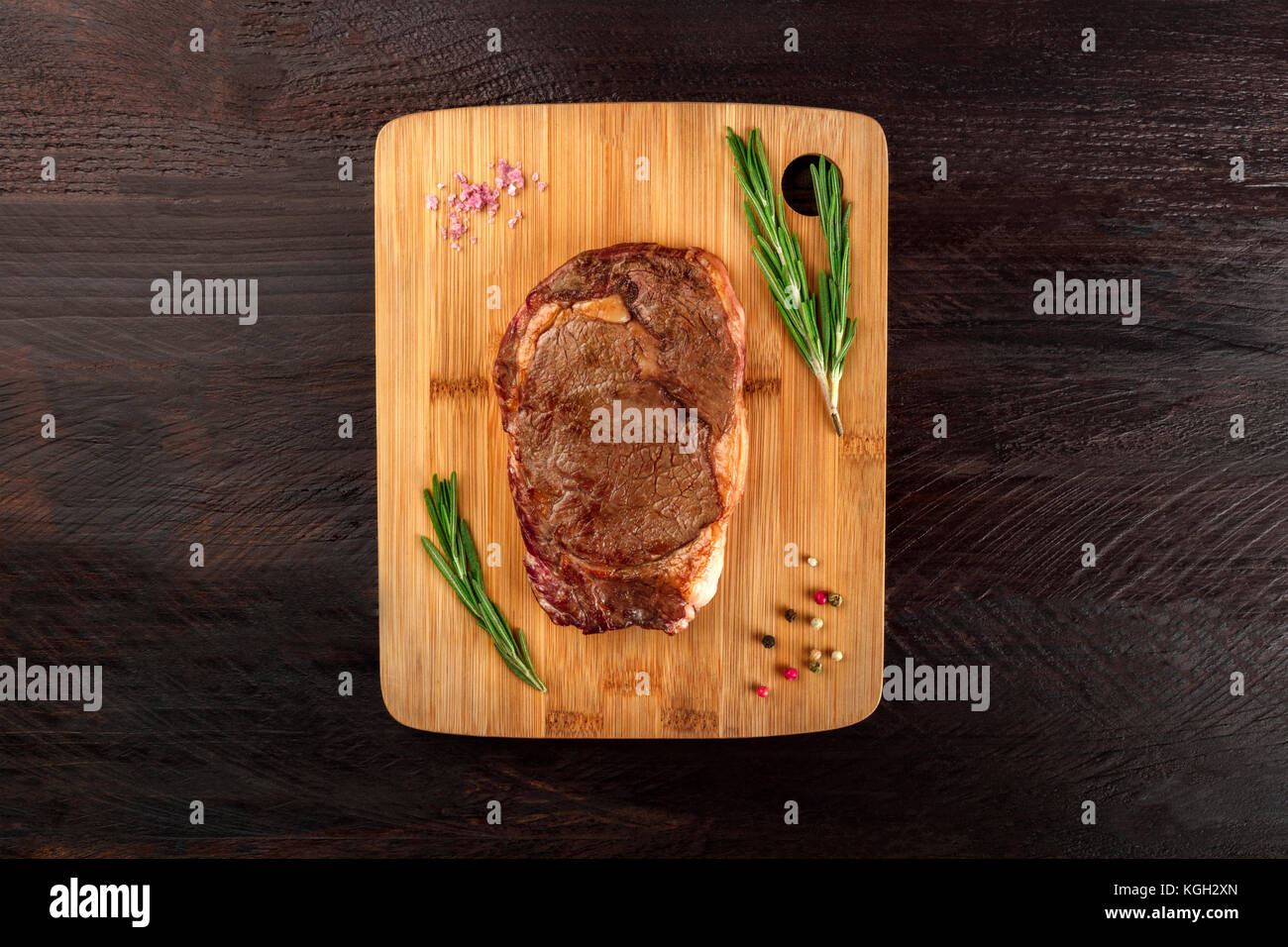 Cooked meat on rustic textures with seasoning and copyspace Stock Photo ...