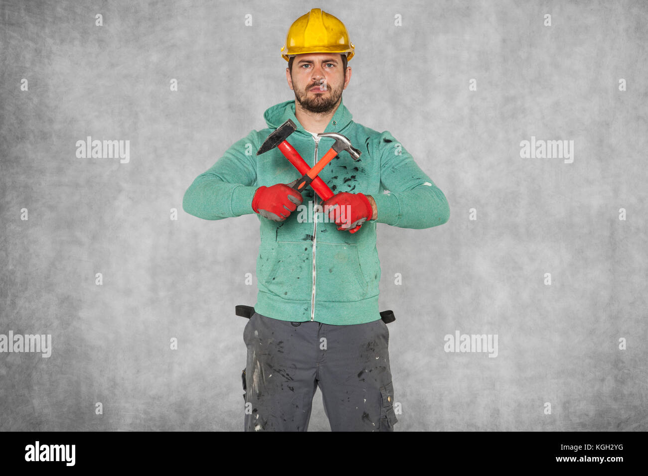 Workman crosses two hammers, ready to work Stock Photo - Alamy