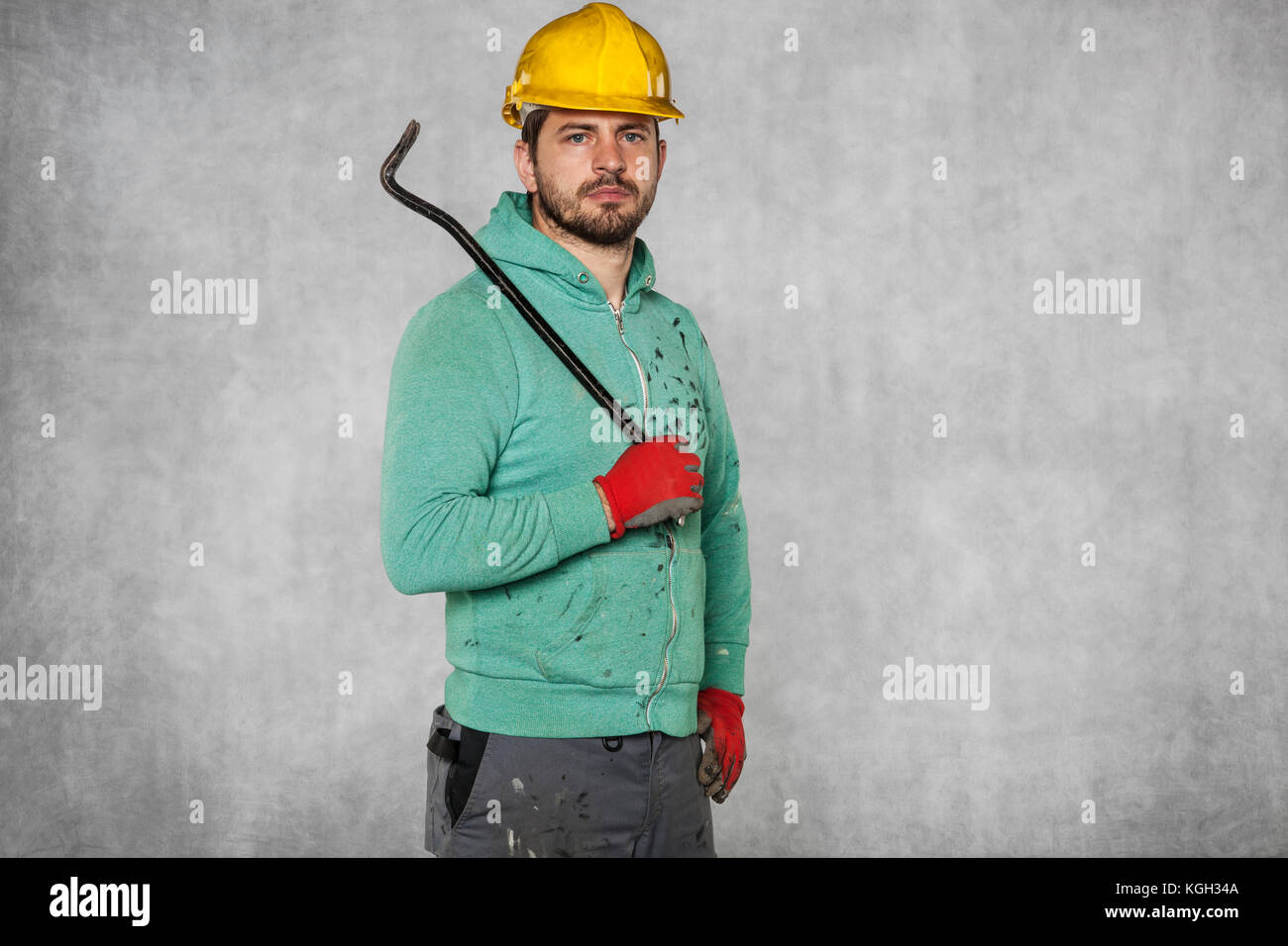 Worker holding a crowbar in his hand Stock Photo - Alamy