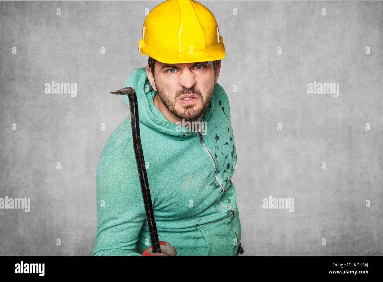 An angry worker holds a crowbar in his hand Stock Photo - Alamy