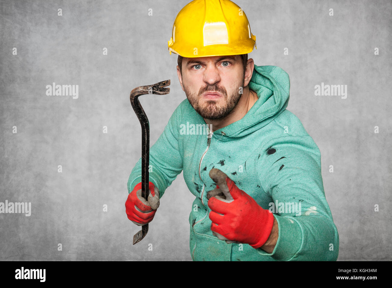 Disgruntled worker threatens with a crowbar and shows a finger Stock ...