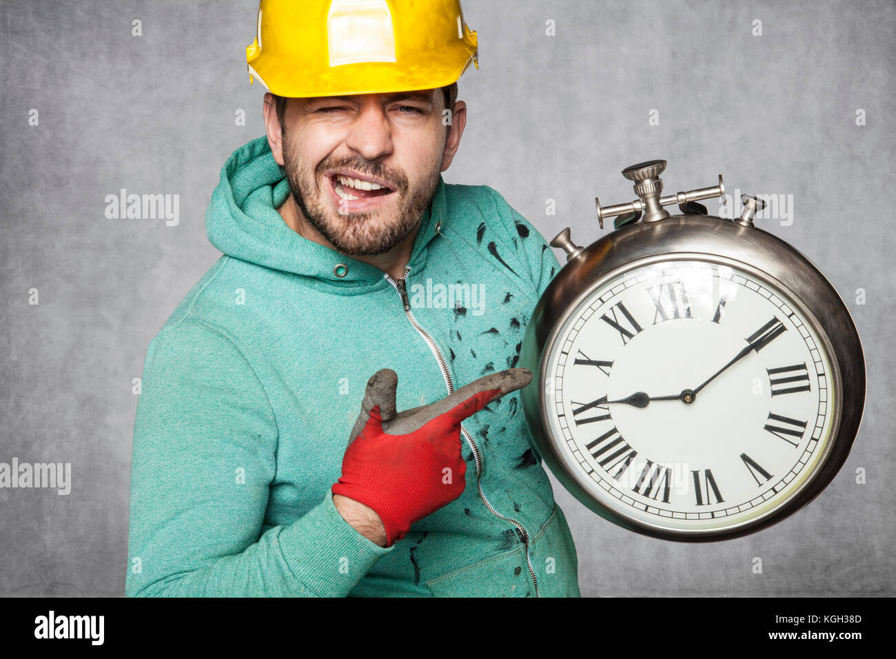 The worker keeps the clock and indicates it Stock Photo - Alamy