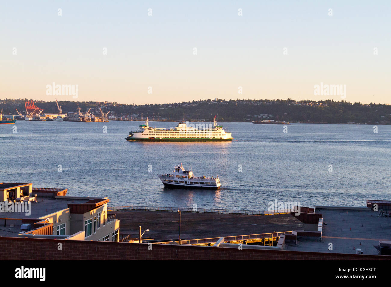 Tour boats in Seattle, Washington harbor with late afternoon sunlight ...