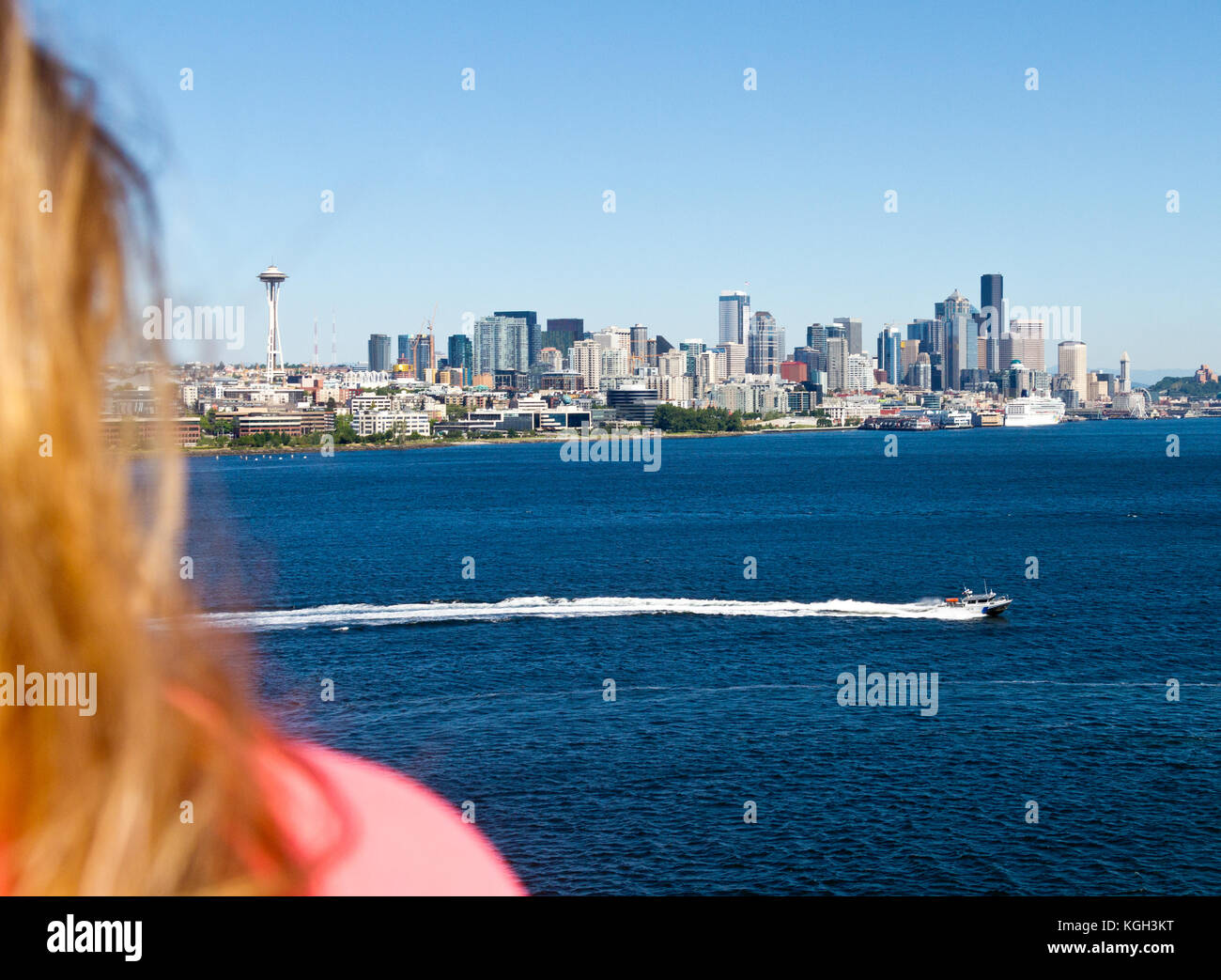 A young woman taking in the view of downtown Seattle from the deck of a ...