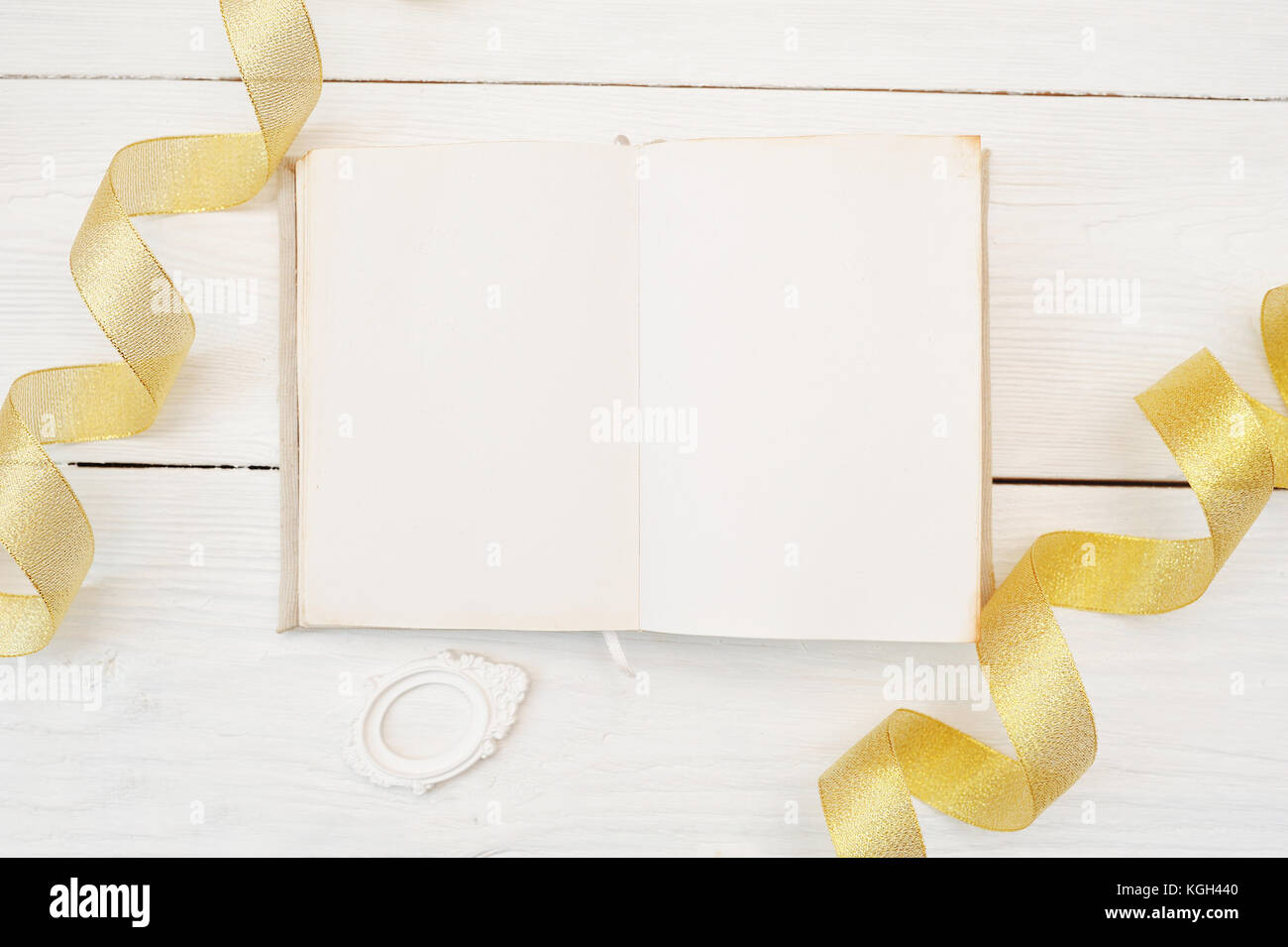 Mock-up open notebook on white wooden background with gold ribbon Stock ...