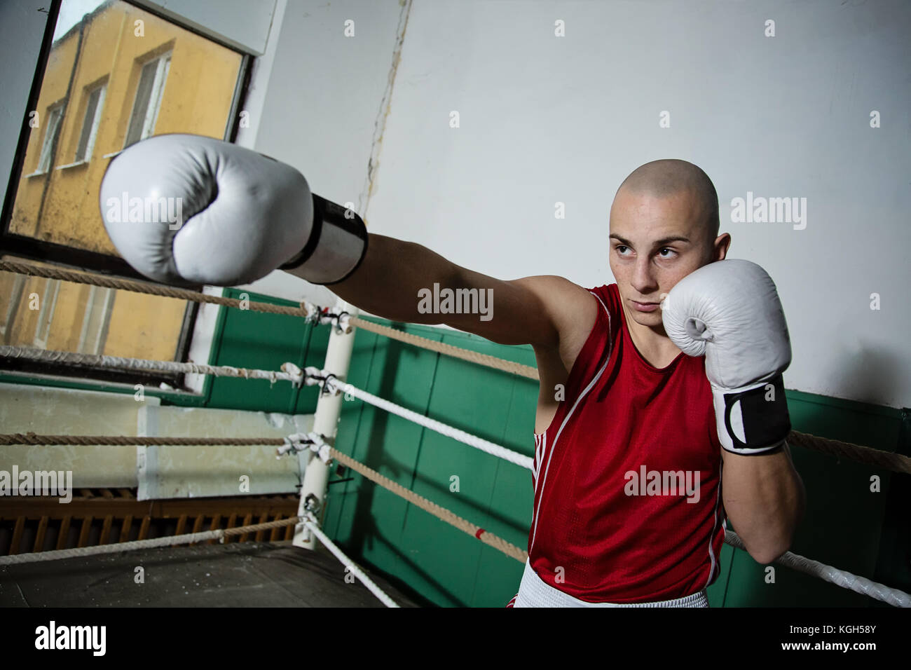 close up of young adult male boxer punching in the air, wearing white ...