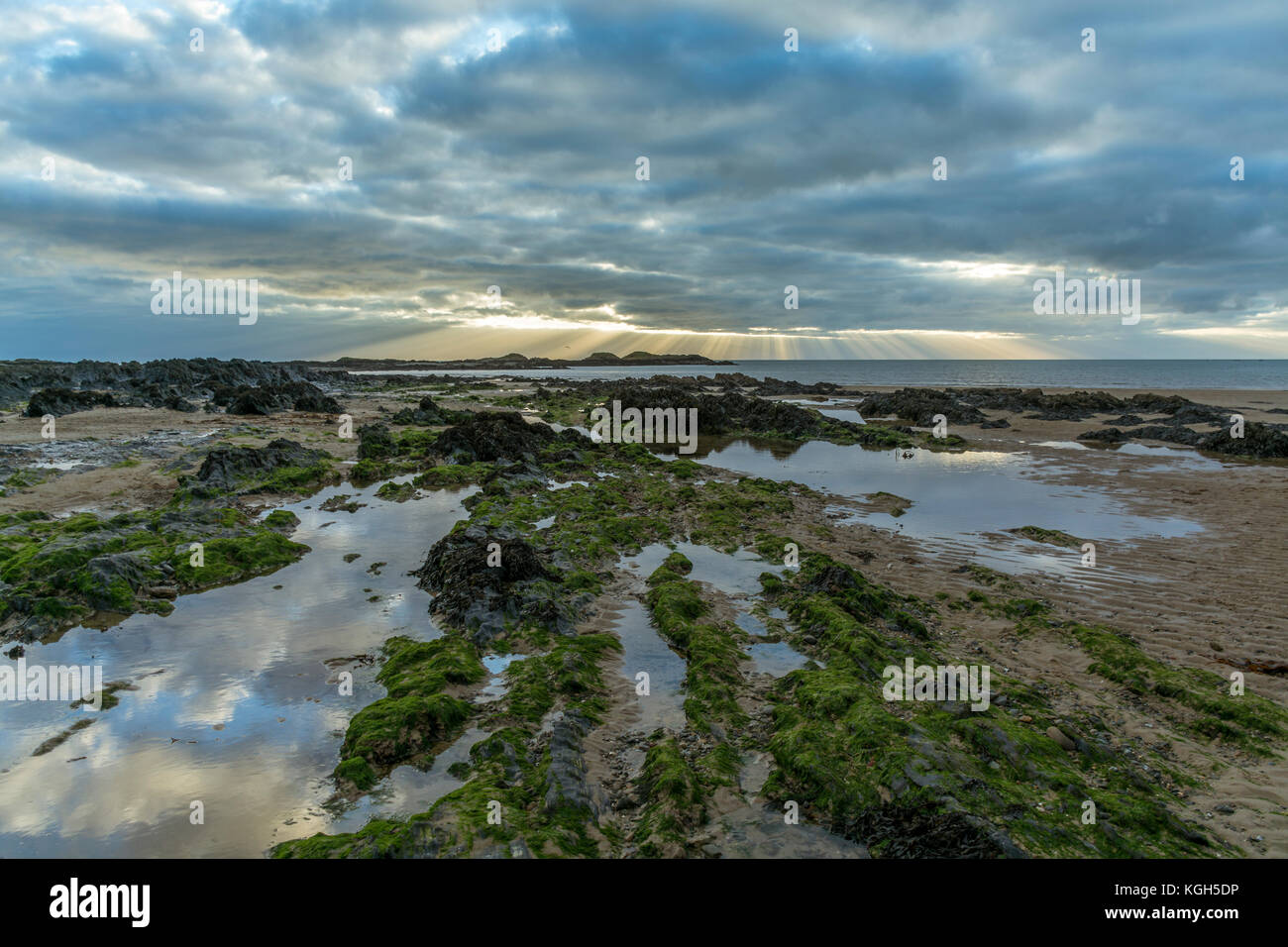 Sun beams on the horizon at the Town beach, Rhosneigr on Anglesey Stock ...