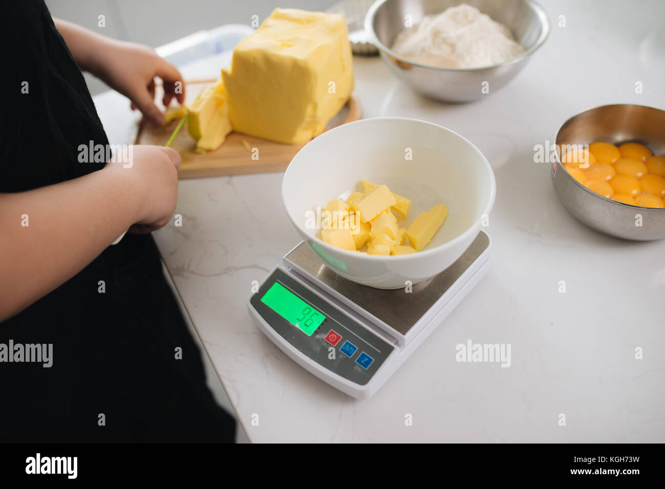 Cropped image of female chef cutting butter in kitchen Stock Photo - Alamy