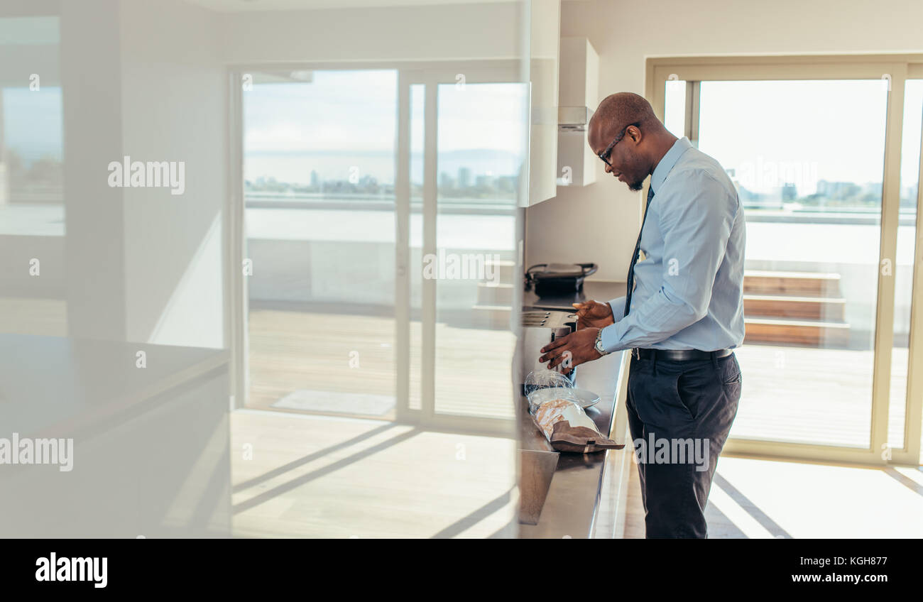 Man dressed in formals preparing breakfast in kitchen. businessman ...