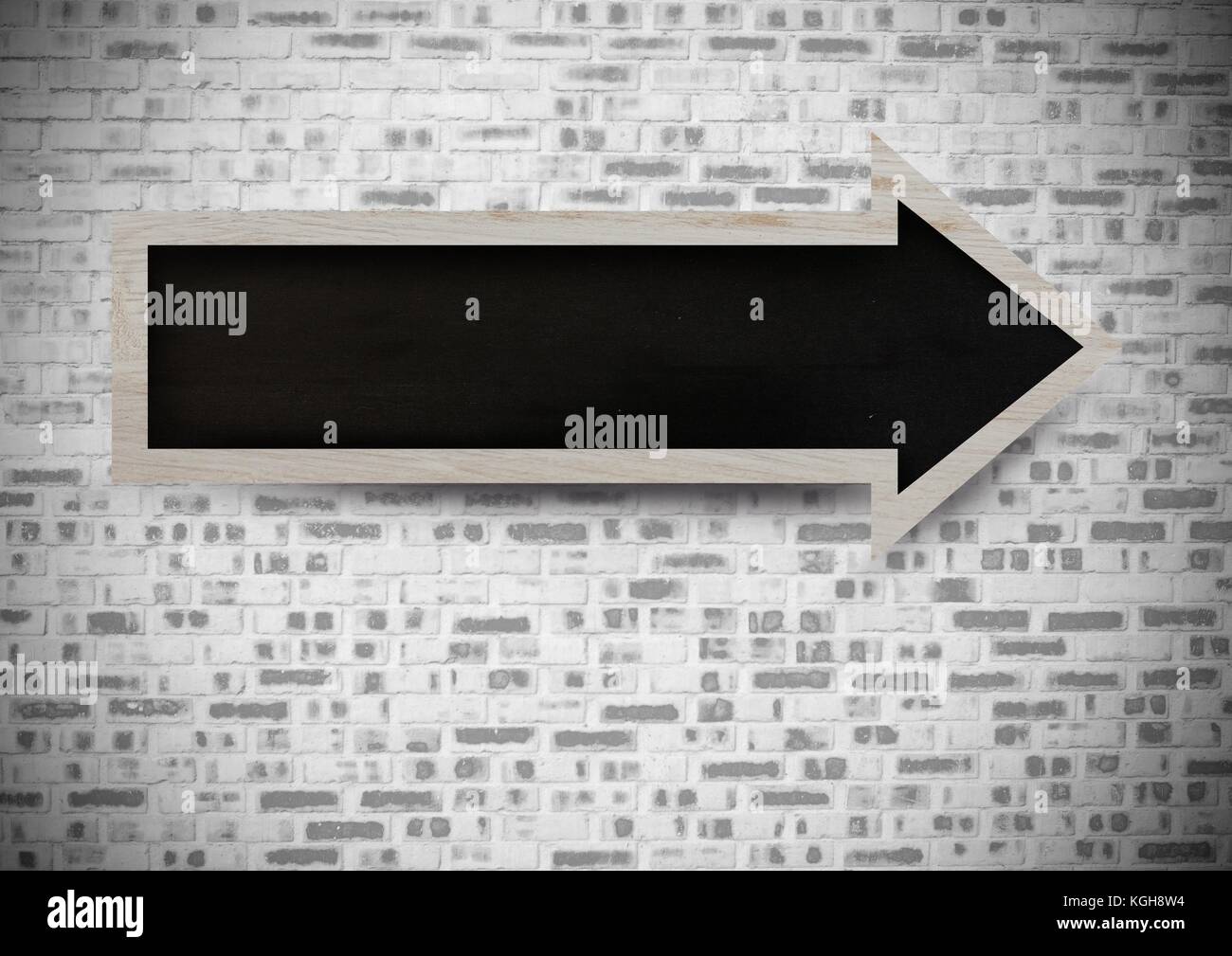 Digital composite of Blackboard arrow sign on wall Stock Photo - Alamy