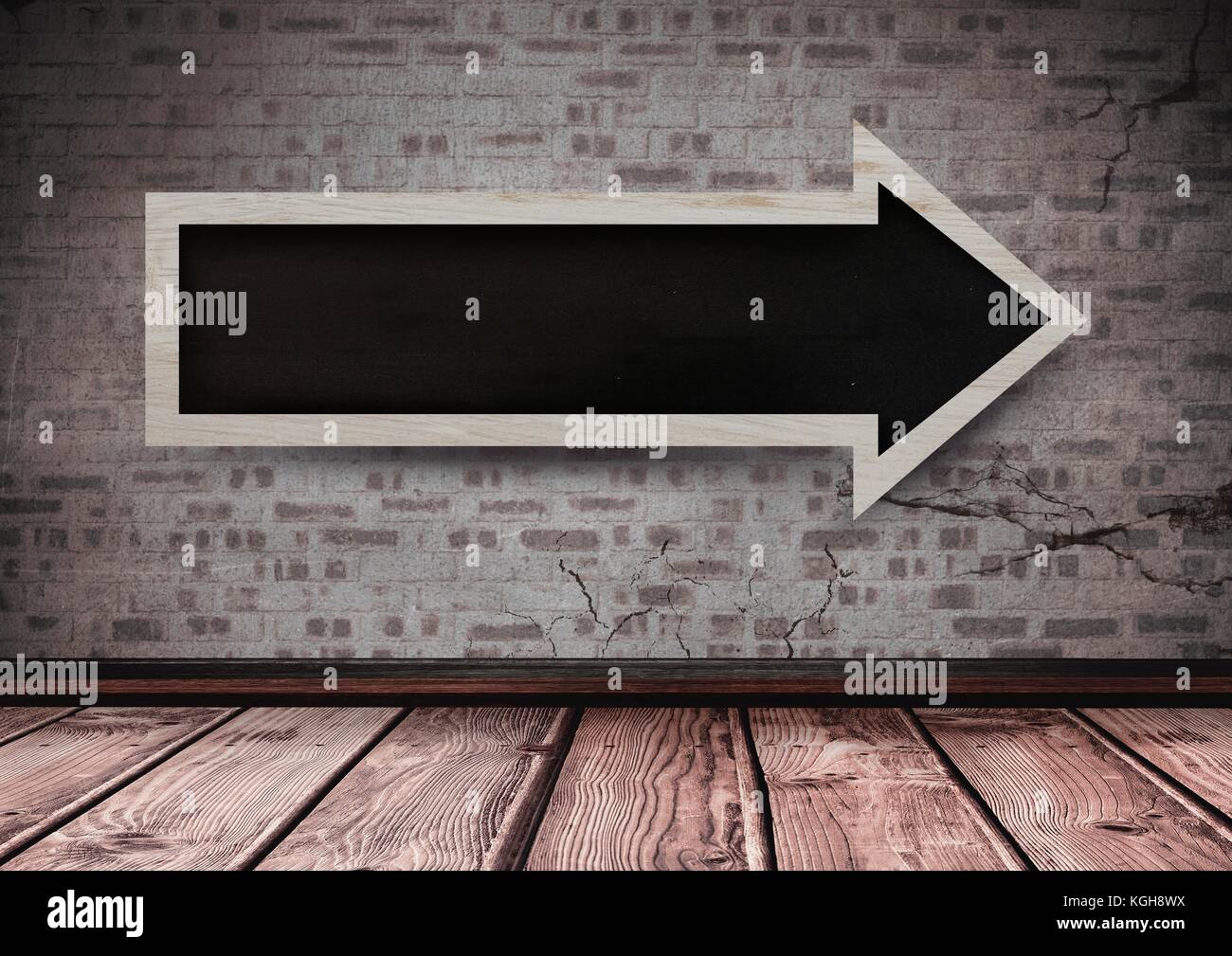 Digital composite of Blackboard arrow sign on wall Stock Photo - Alamy