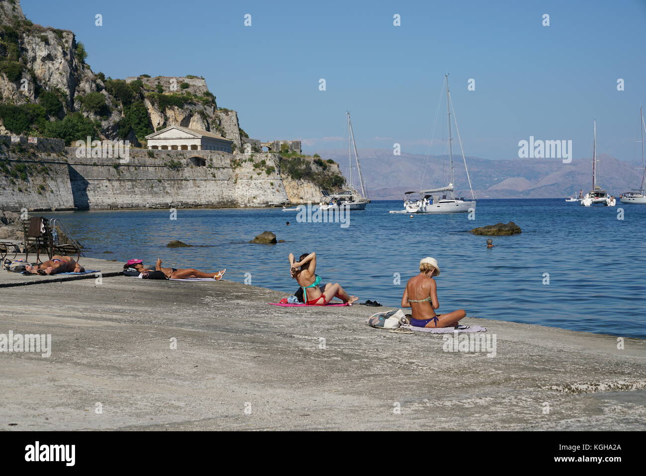 Corfu, Greece: People at the beach swimming and sunbathing Stock Photo ...