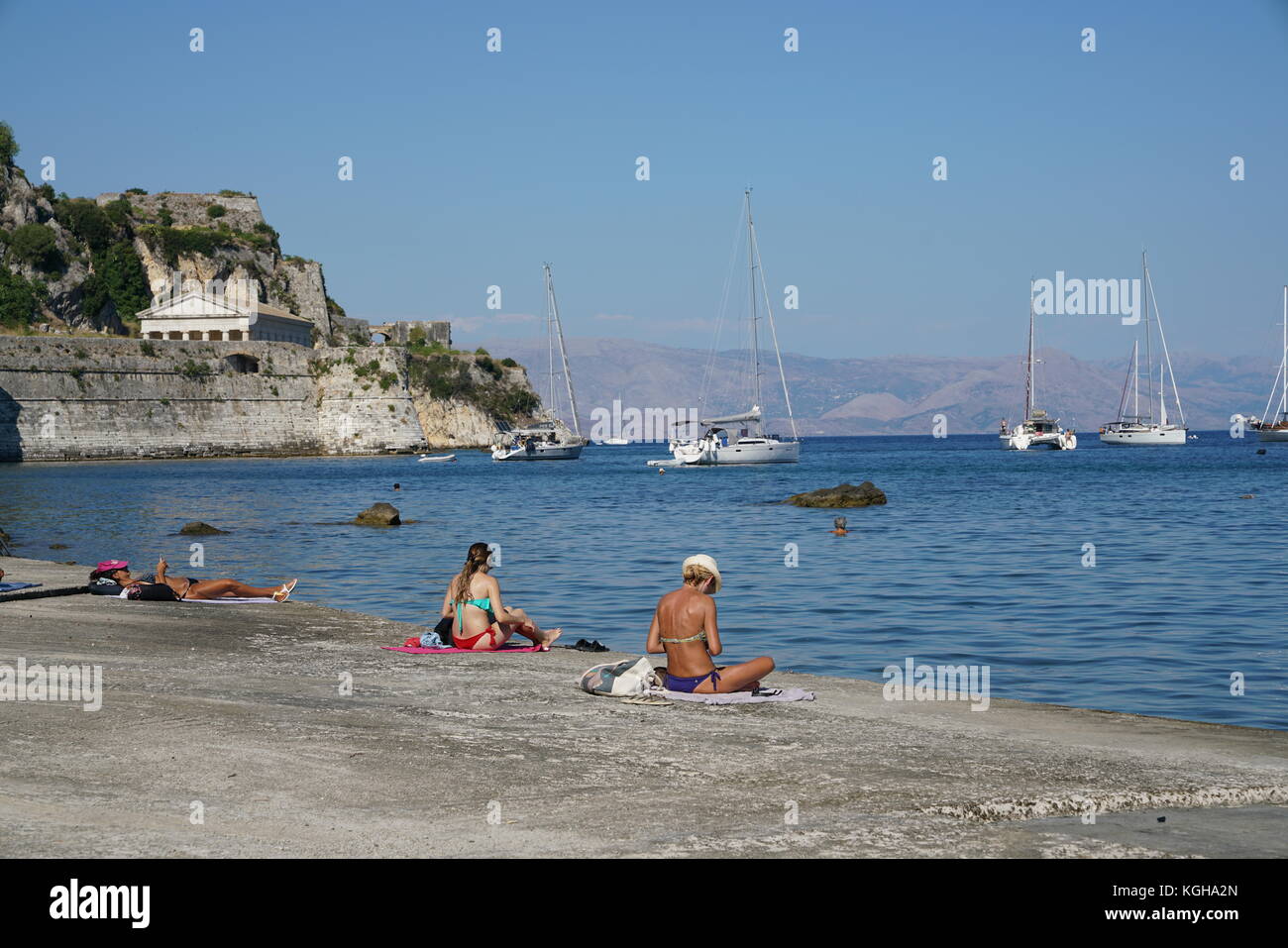 Corfu, Greece: People at the beach swimming and sunbathing Stock Photo ...