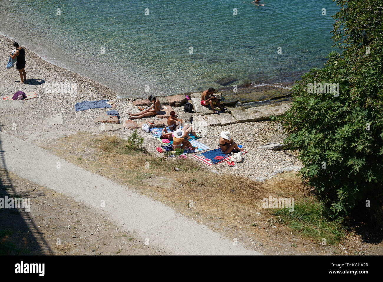 Corfu, Greece: People at the beach swimming and sunbathing Stock Photo ...