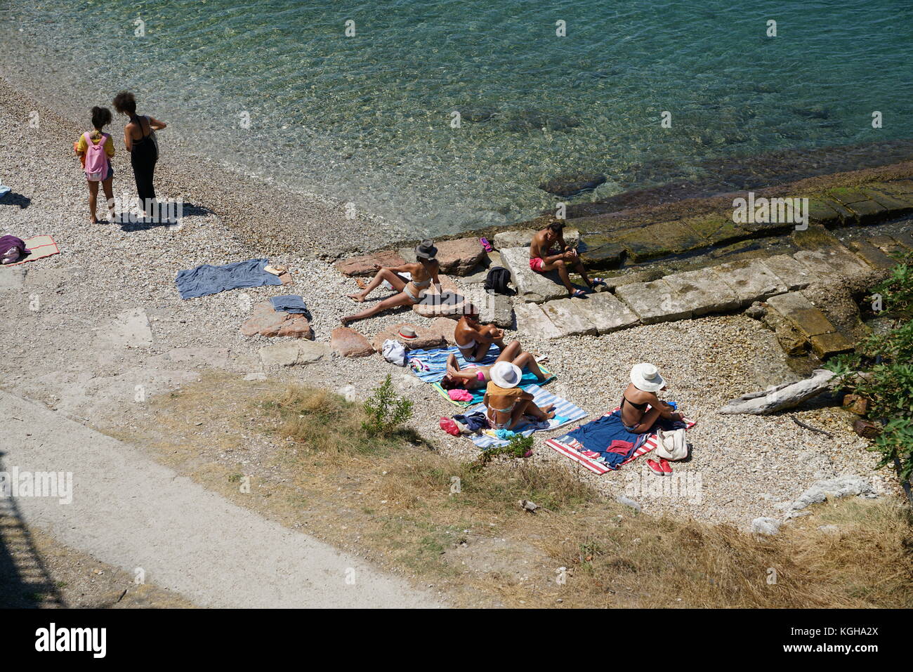 Corfu, Greece: People at the beach swimming and sunbathing Stock Photo ...