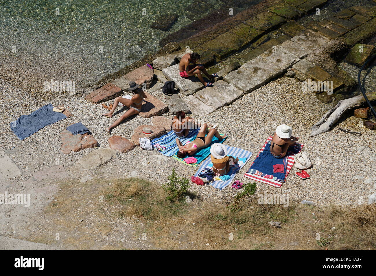 Corfu, Greece: People at the beach swimming and sunbathing Stock Photo ...
